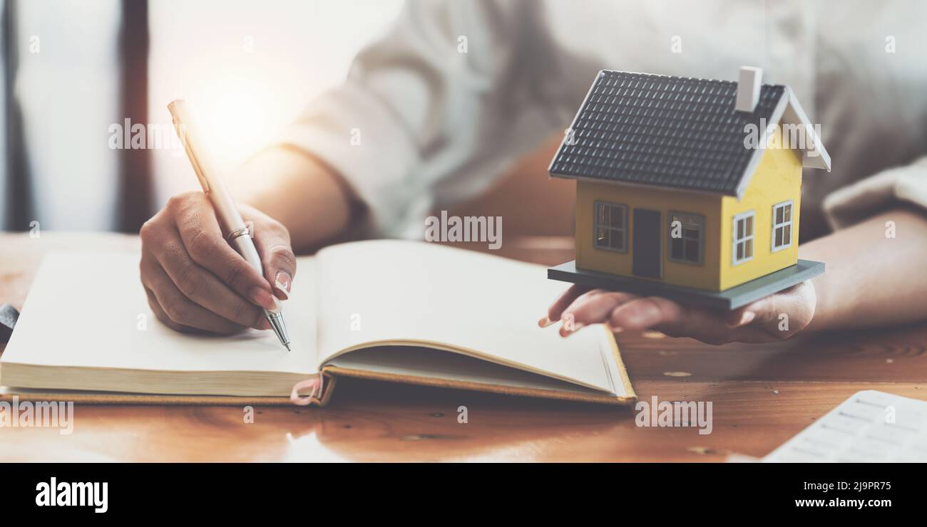A woman holding and checking house model .Real Estate House Appraisal ...