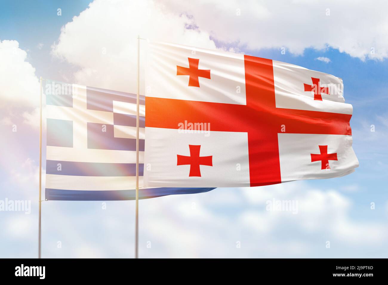 Sunny blue sky and flags of georgia and greece Stock Photo - Alamy