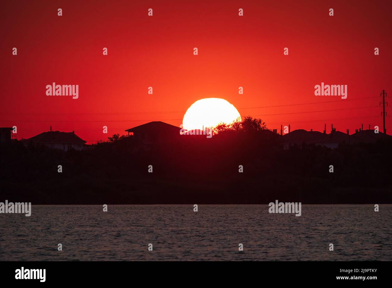The sun goes down over a lake. Dramatic Sunset Sky Stock Photo - Alamy