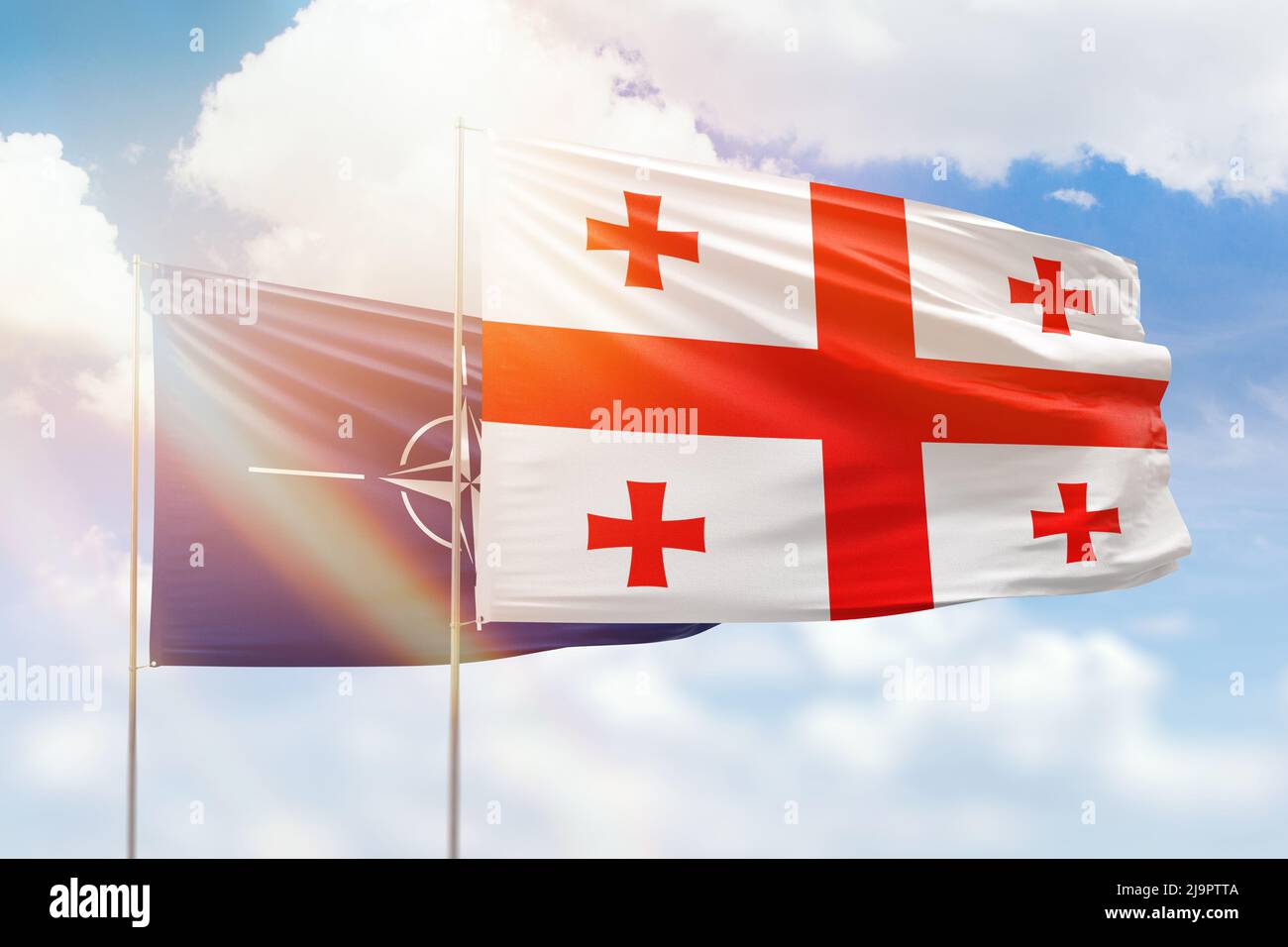 Sunny blue sky and flags of georgia and nato Stock Photo - Alamy