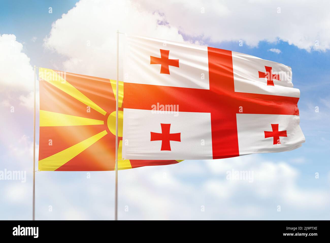 Sunny blue sky and flags of georgia and north macedonia Stock Photo - Alamy