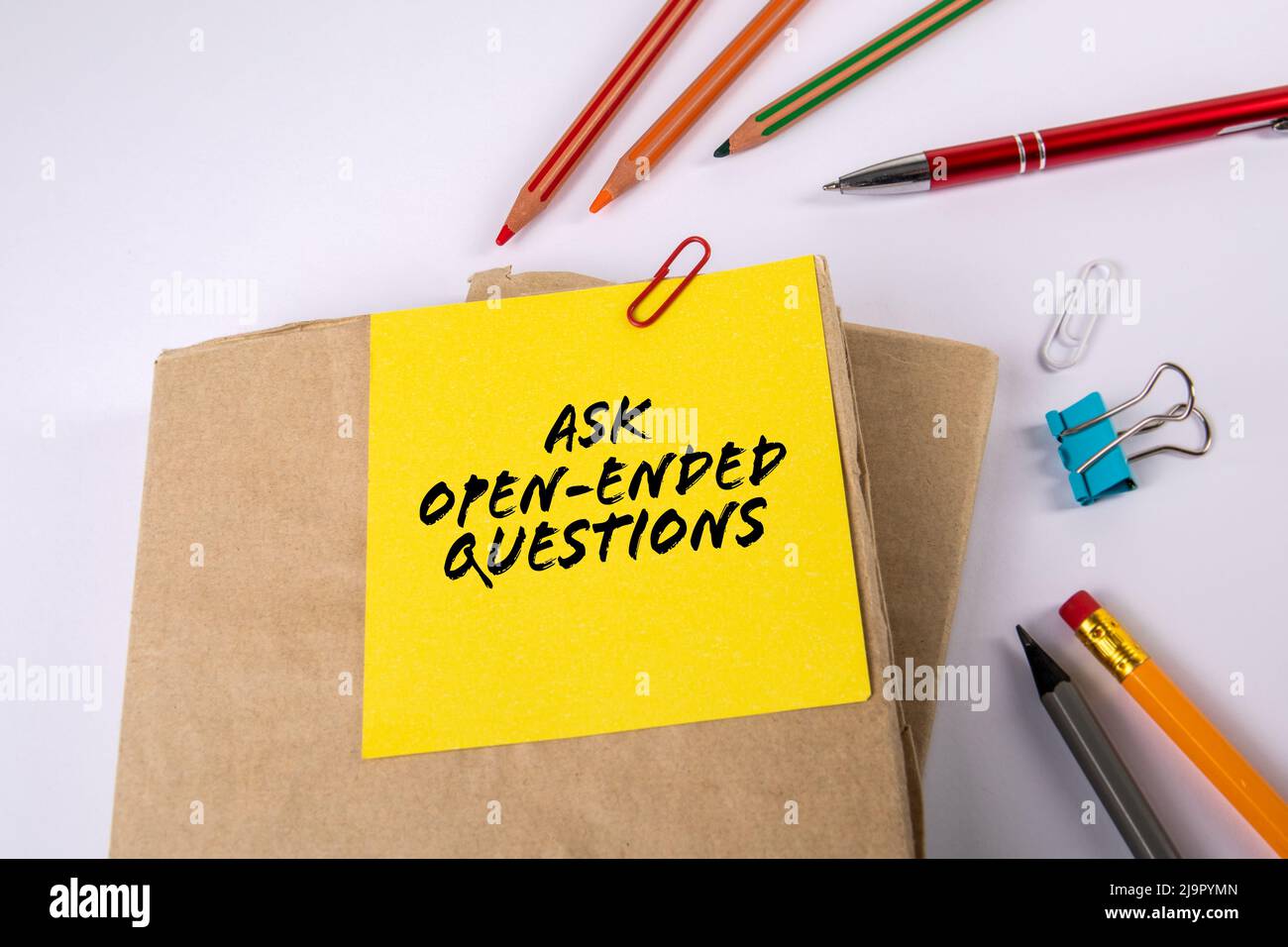 ASK OPEN-ENDED QUESTIONS. Stack of books on a white office desk Stock ...