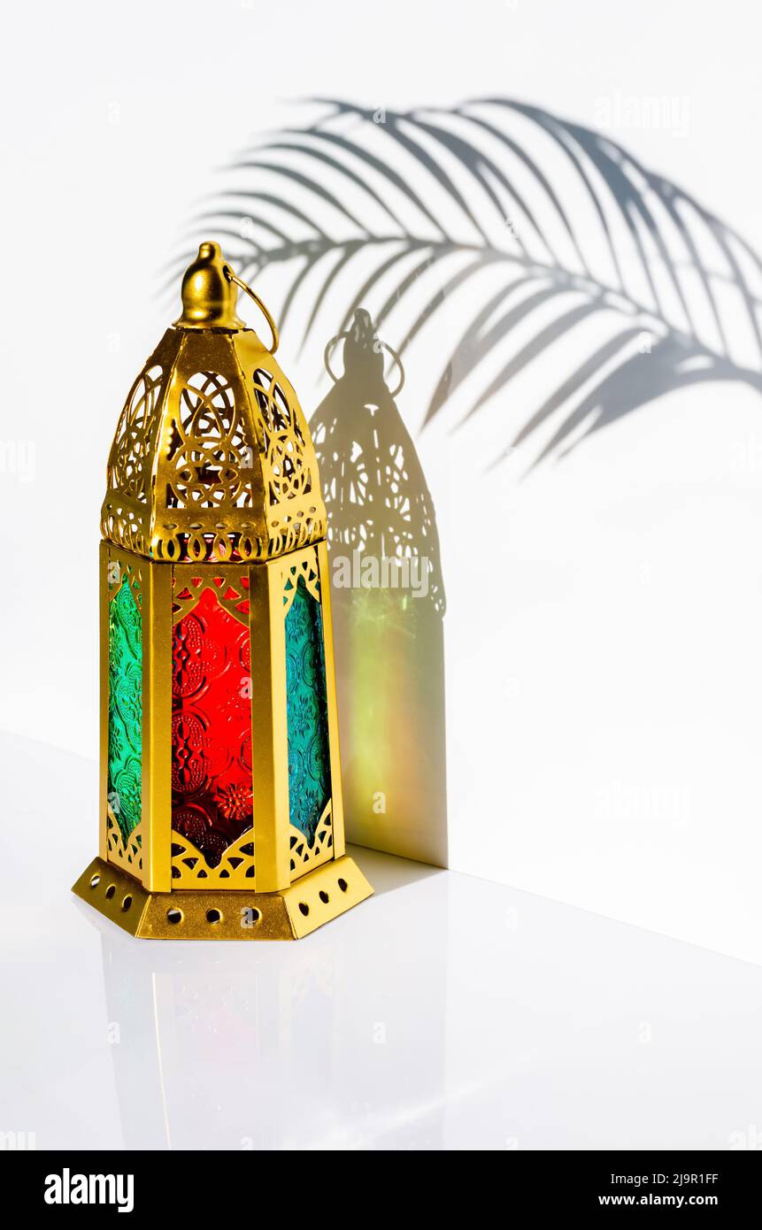 Golden lantern with shadow from sun light and leaf on white background ...