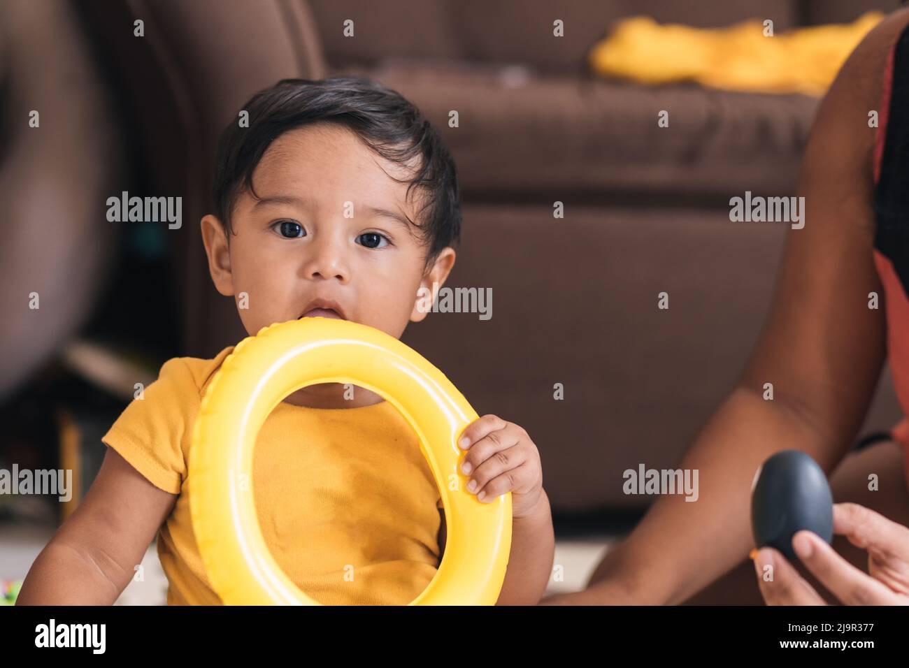 child sitting on the floor playing with yellow balloon Stock Photo - Alamy