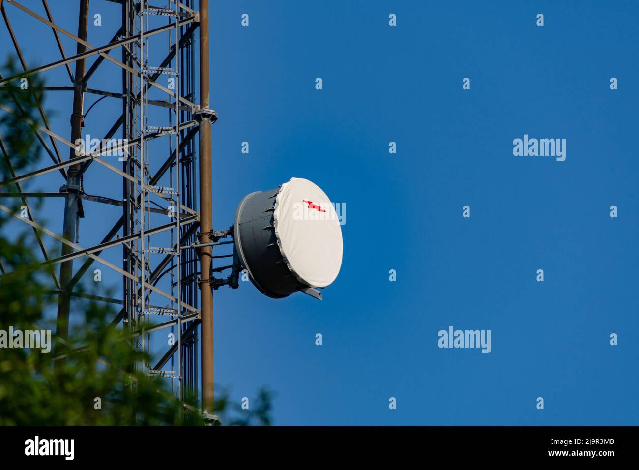 Round Satellite Dish Mounted on a Larger Antenna Structure Against Blue ...