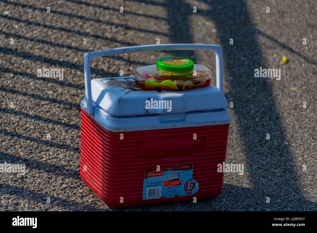 Red Fishing Tackle Box with Gear on Sunlit Pavement Stock Photo - Alamy