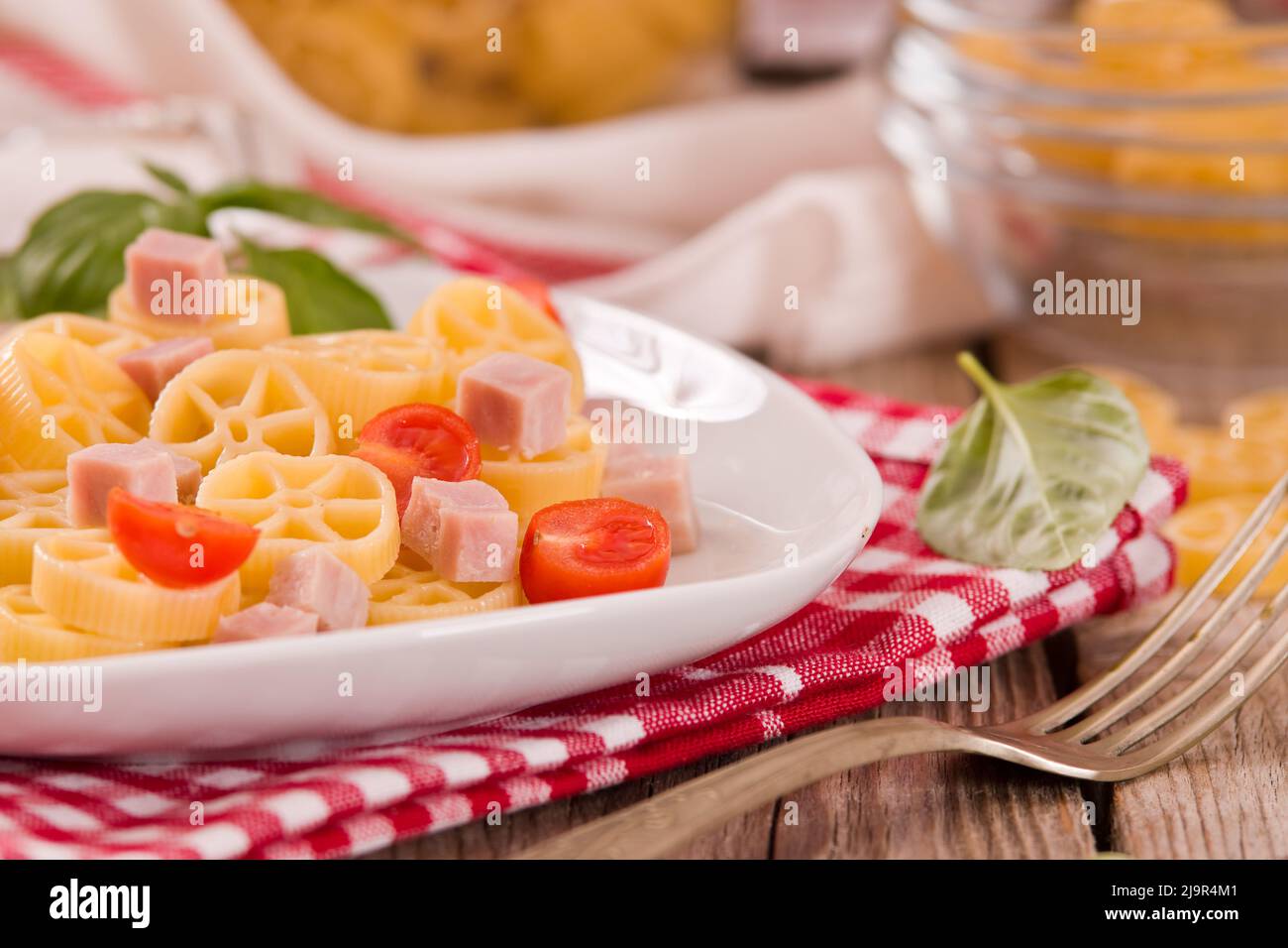 Ruote pasta with tomato and ham Stock Photo - Alamy