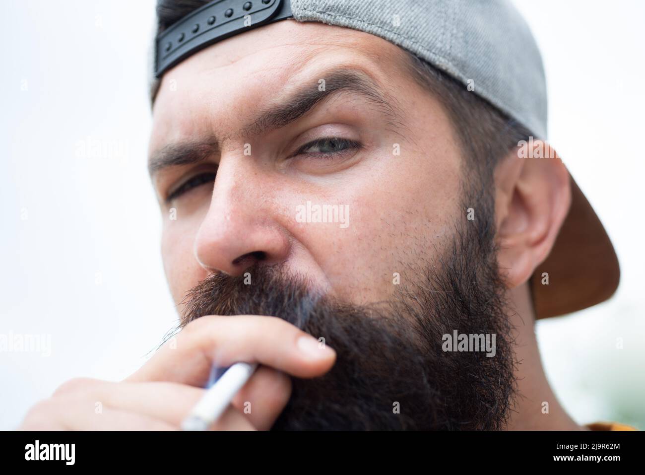 Closeup portrait of man man smoking cigarette. Handsome guy smoking ...
