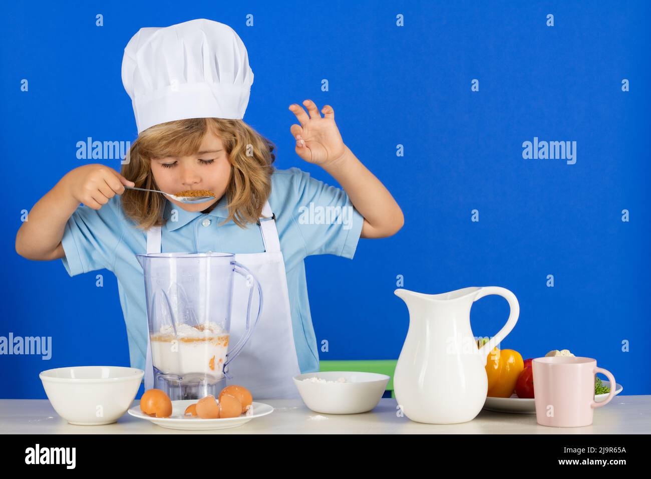 Cooking children. Chef kid boy making fresh vegetables for healthy eat ...