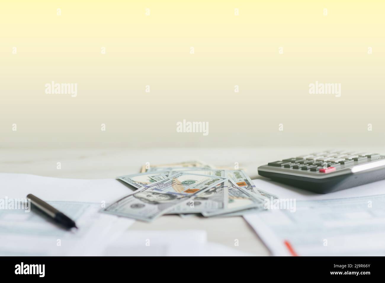 Working desk with tax form, cash money one hundred dollar bills and ...