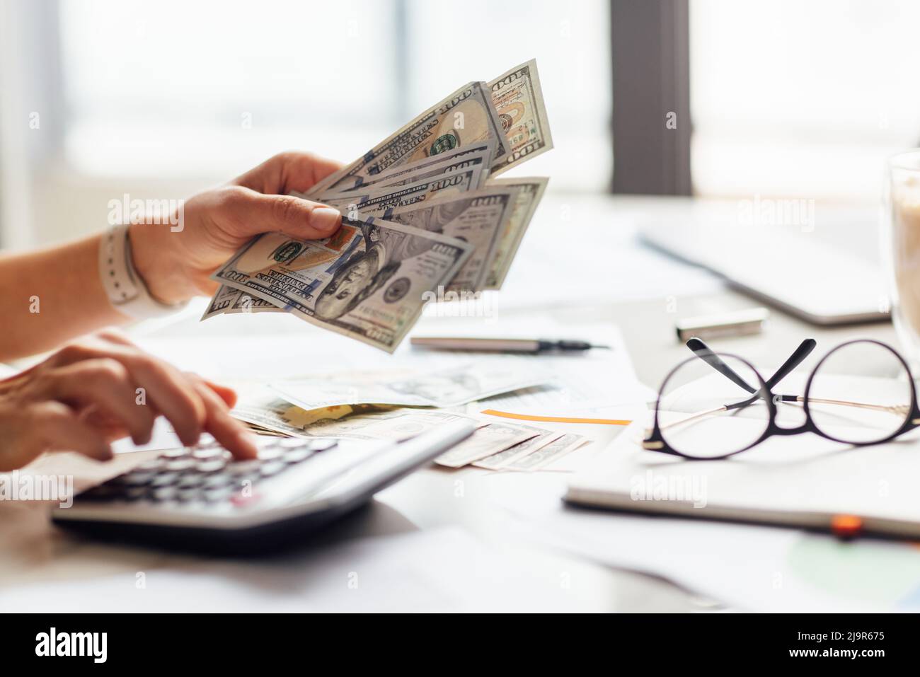 Close up young business woman using counting cash money one hundred ...