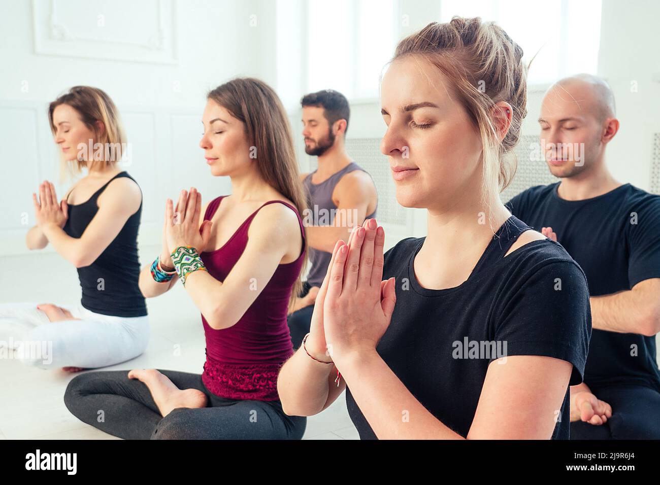 a happy group of people from men and women practicing yoga in the ...