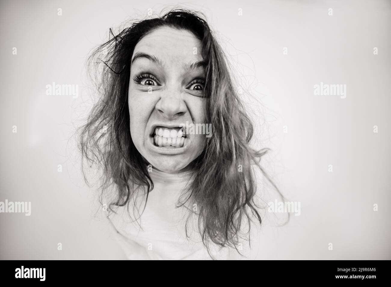 Close-up portrait of insane woman in straitjacket on white background. Monochrome Stock Photo ...