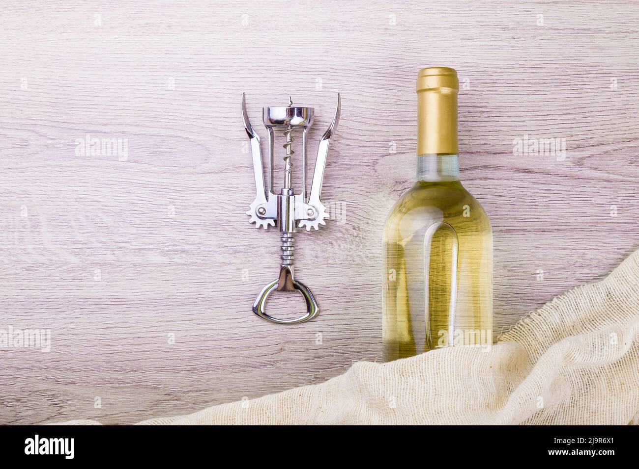 Wine bottle with corkscrew on wooden background Stock Photo - Alamy