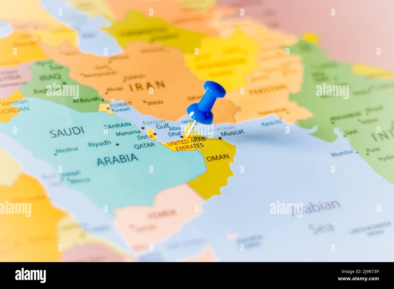 Blue push pin pointing at United Arab Emirates on a political world map ...