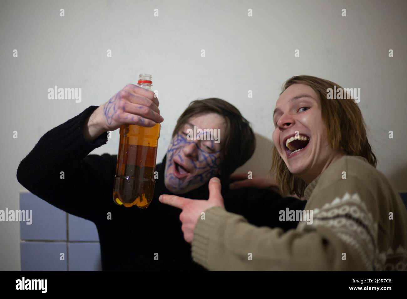 Guys drink alcohol at a party. Crazy guys having fun with beer. The guy ...