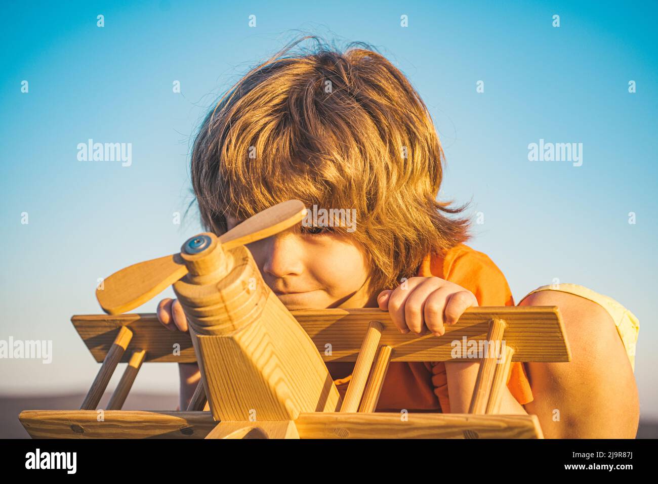 Kid dreaming and plays with a toy plane in the park. Dreams of travel ...