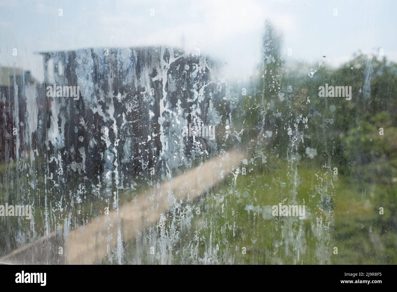 Dirty glass lit by the sun. Unclean window soiled with dust stains ...