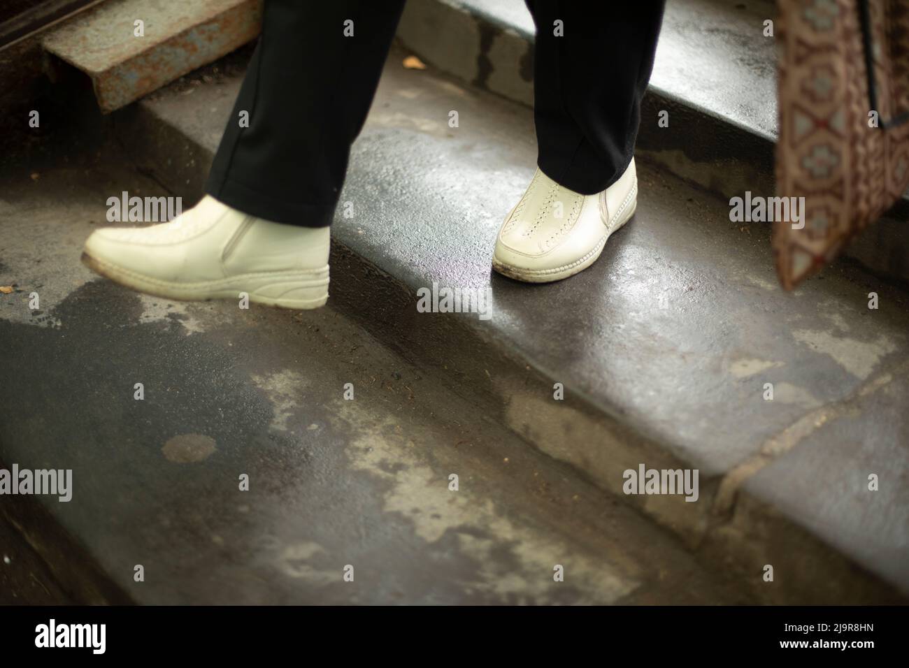 Feet go up steps. White shoes. Move up stairs. Man in town Stock Photo ...