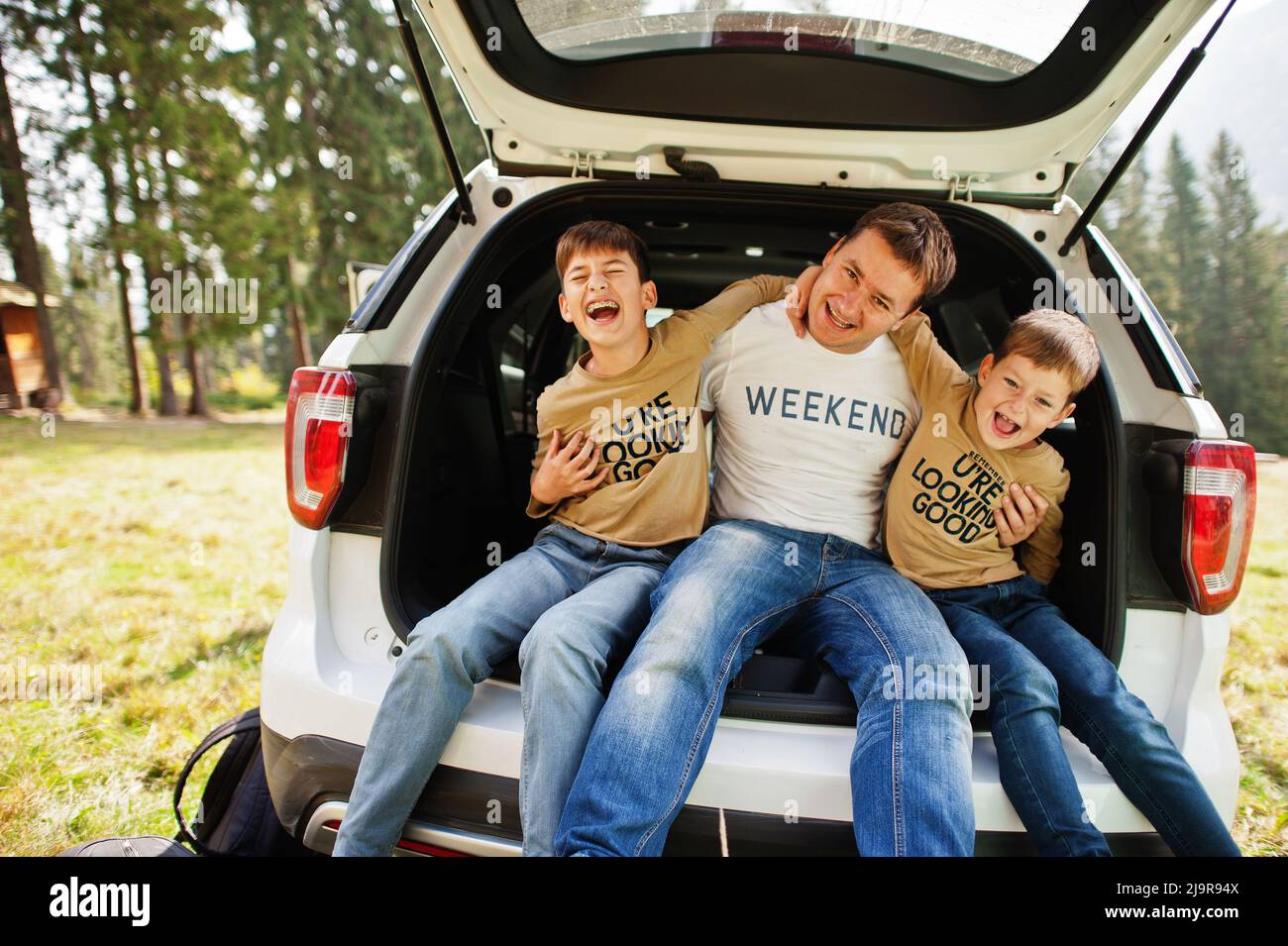 Family at vehicle interior. Father with his sons. Children in trunk ...