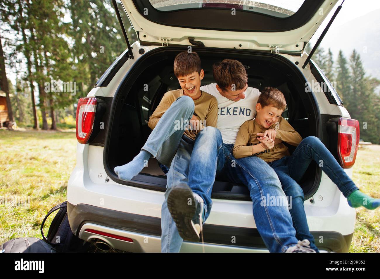 Family at vehicle interior. Father with his sons. Children in trunk ...