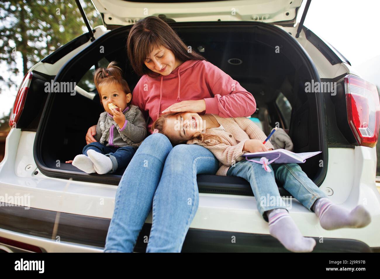 Family at vehicle interior. Mother with her daughters. Children in ...