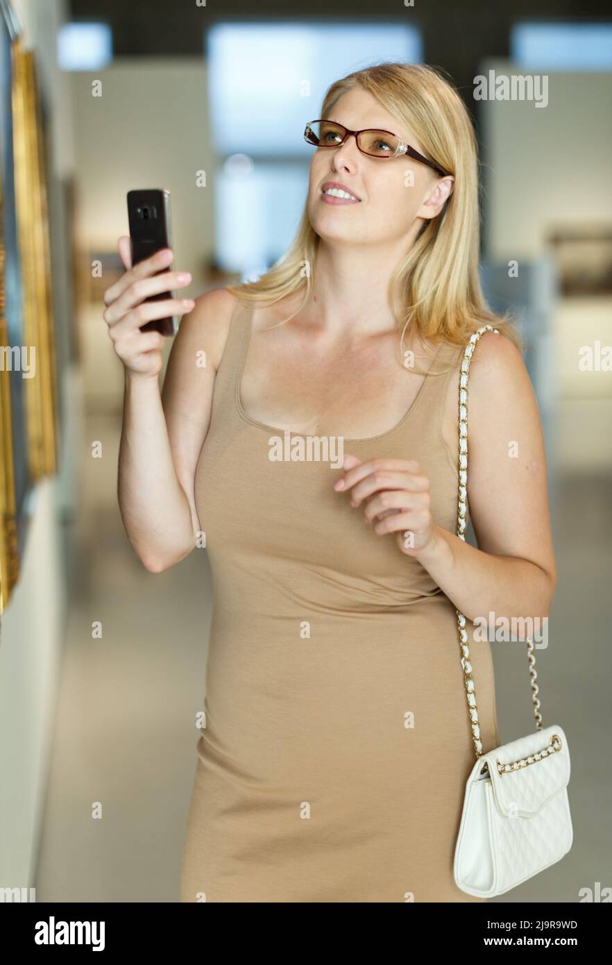Woman looking at exposition and taking pictures Stock Photo - Alamy