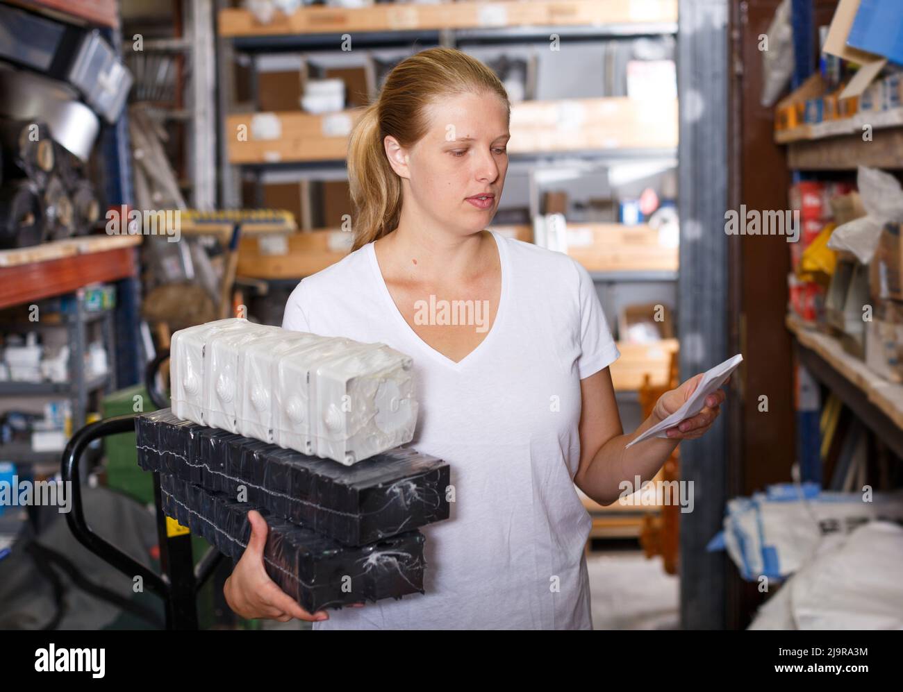 Female holding shop list and construction materials in modern build ...