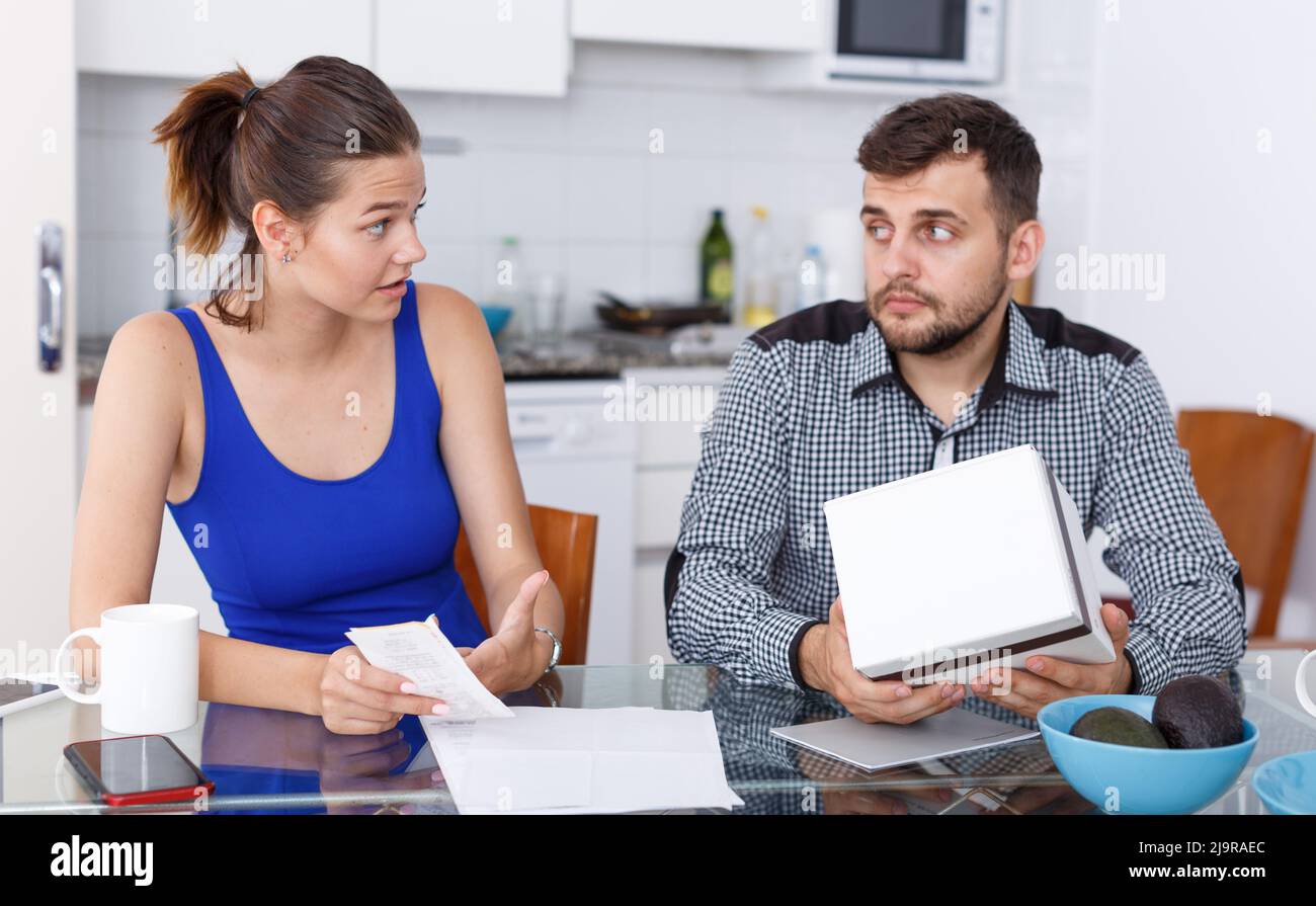 Unhappy young woman and man with box of purchase having conflict Stock ...
