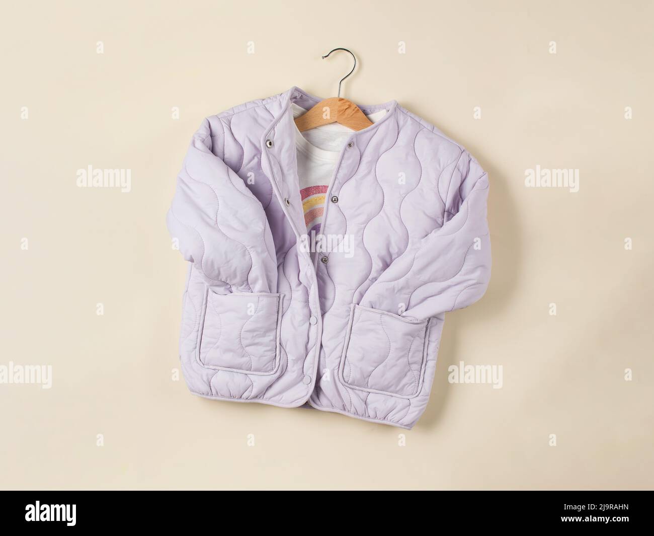 Children's lilac jacket and white T-shirt with a rainbow on a hanger on ...