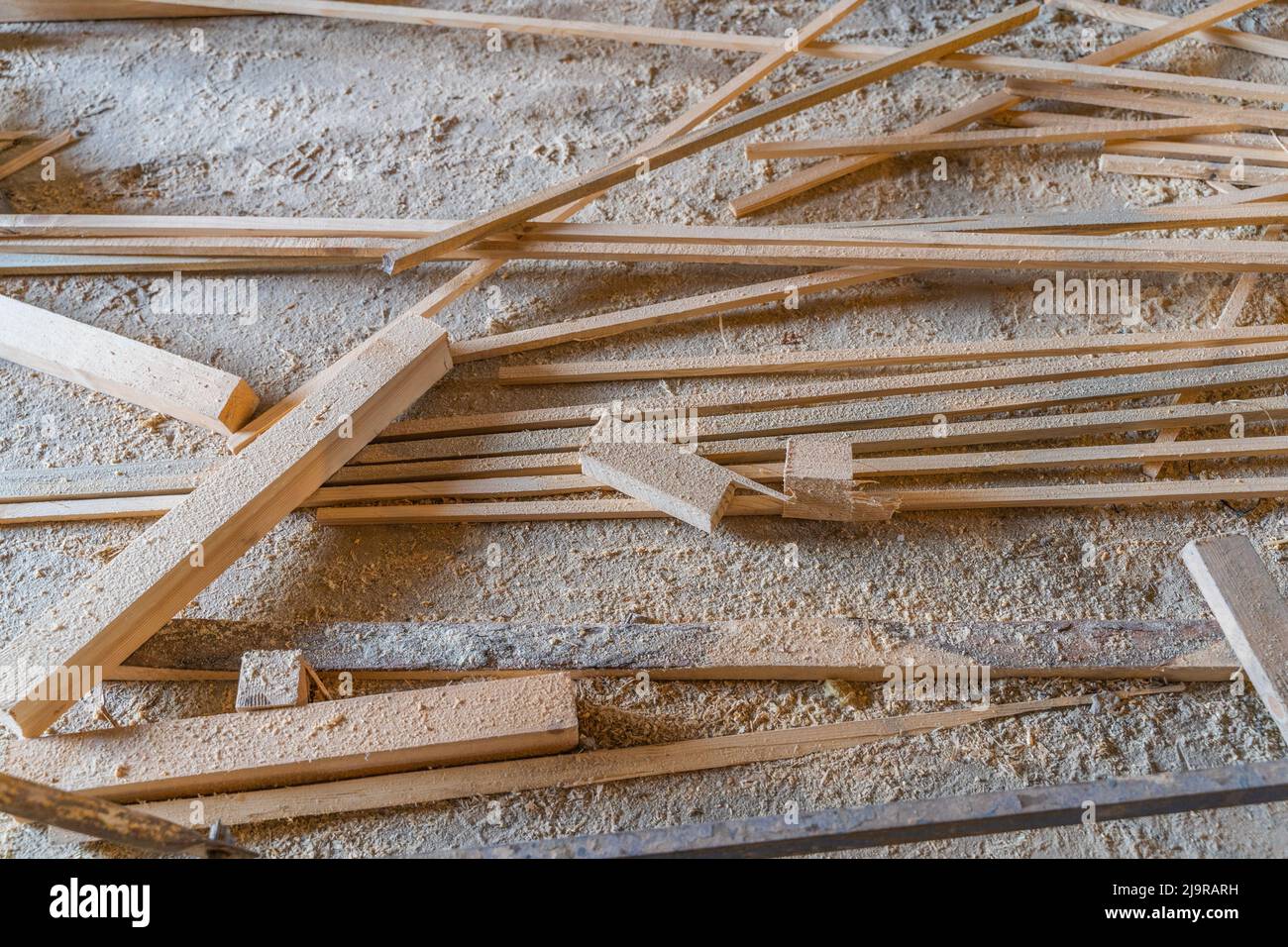 Carpentry waste is covered with sawdust on the floor. Wooden planks and ...