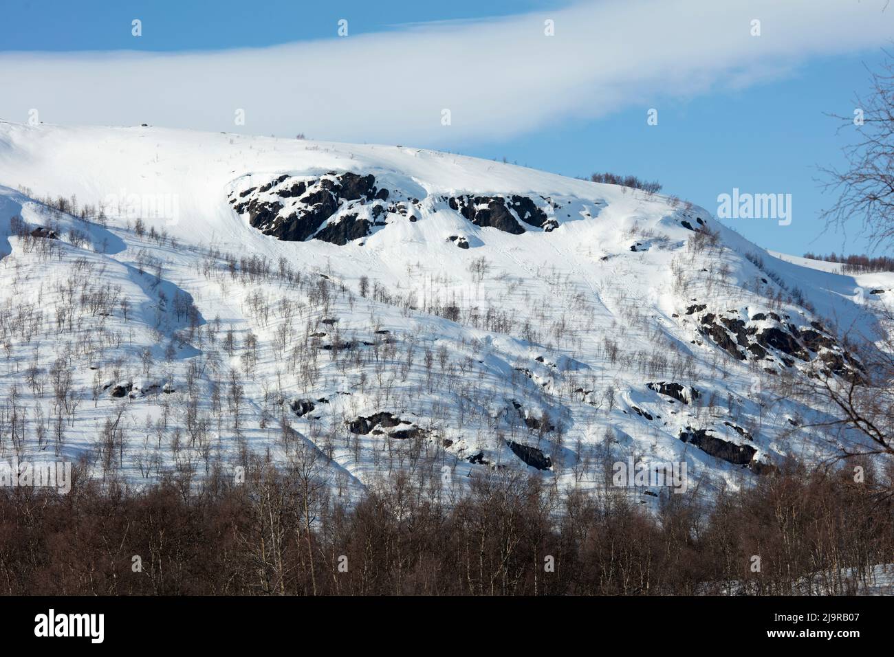 Scandinavian Mountains in March. Bright sunshine, thaw on the hillside ...