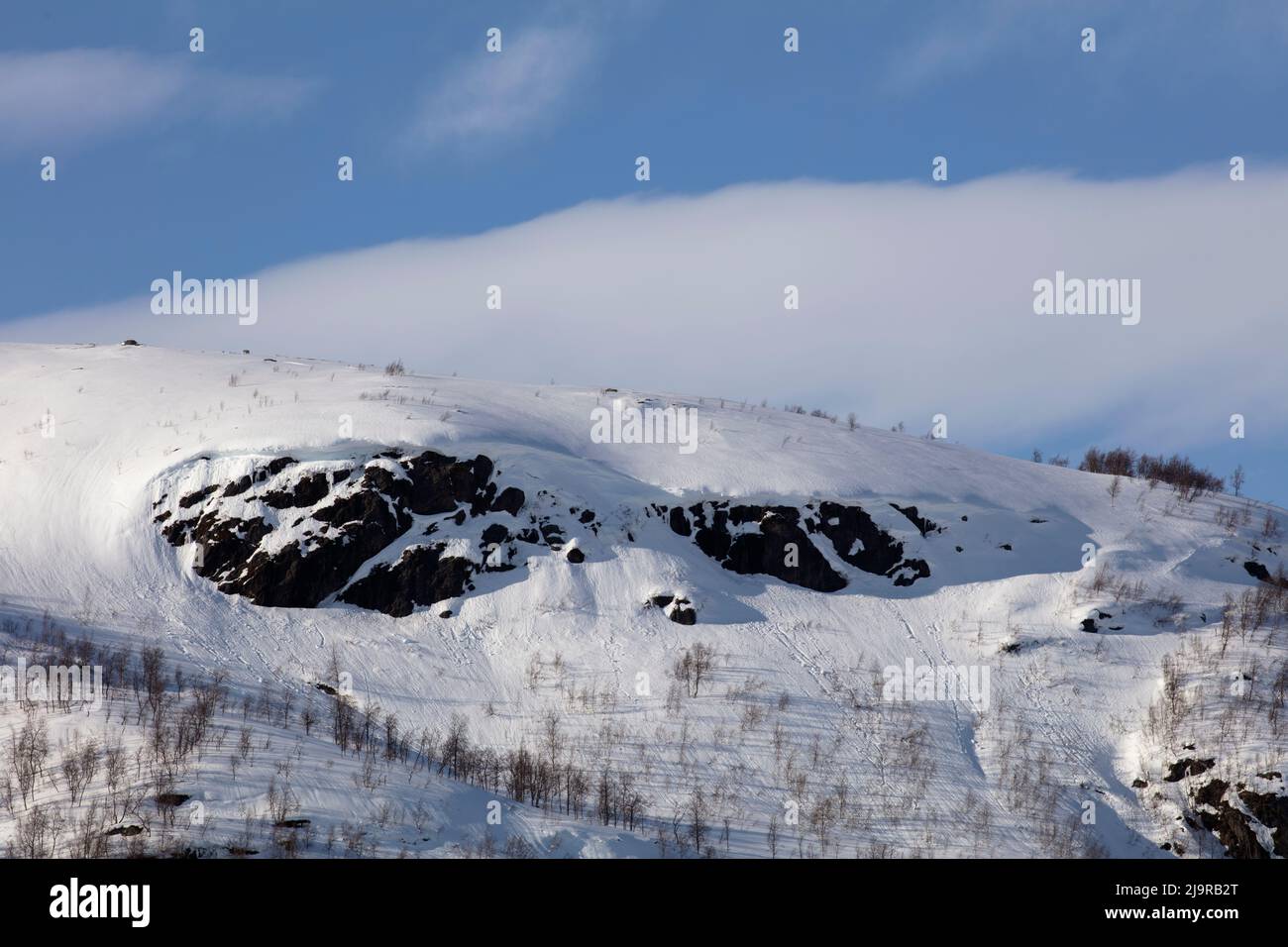 Scandinavian Mountains in March. Bright sunshine, thaw on the hillside ...