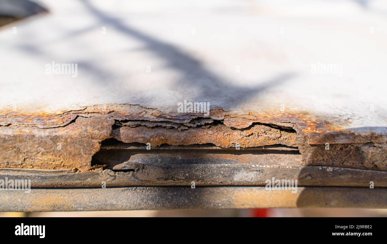 Rusted through the bottom of the door of a white car close-up Stock ...