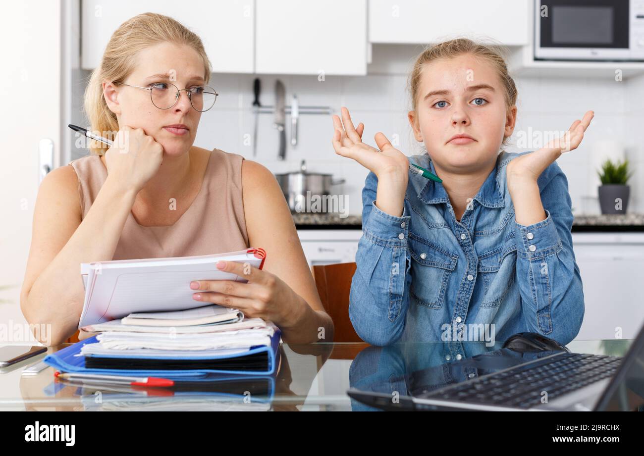 Strict woman supervising study of her daughter Stock Photo - Alamy