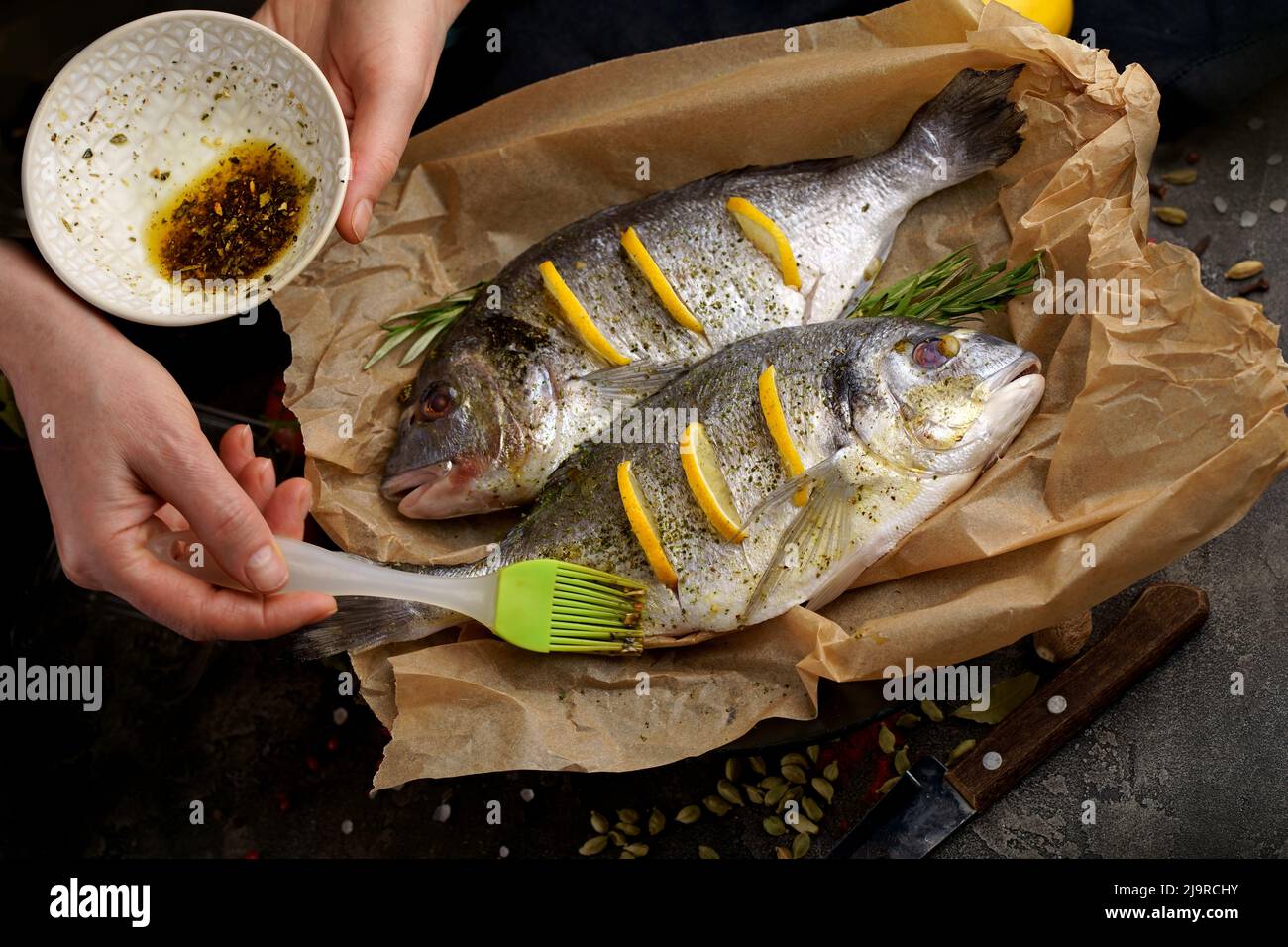 cooking sea fish. Raw dorado fish with spices cooking on cutting board ...