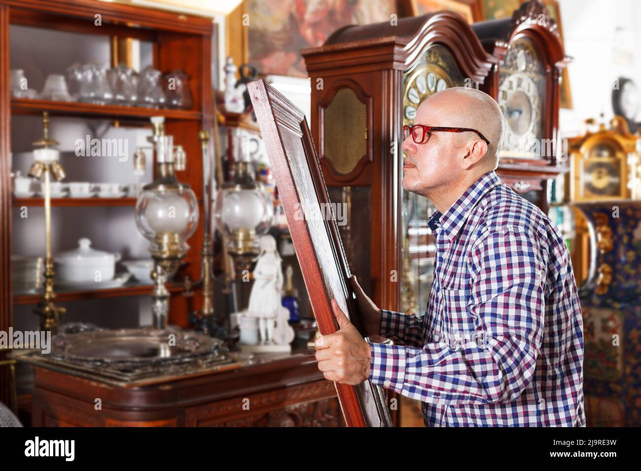 Man choosing ancient things in store Stock Photo - Alamy