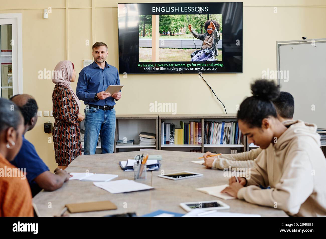 Horizontal shot of multi-ethnic group of migrants attending English ...