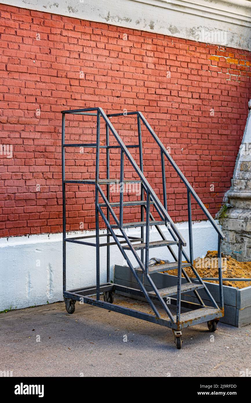 mobile ladder on wheels stands against the wall. High quality photo ...