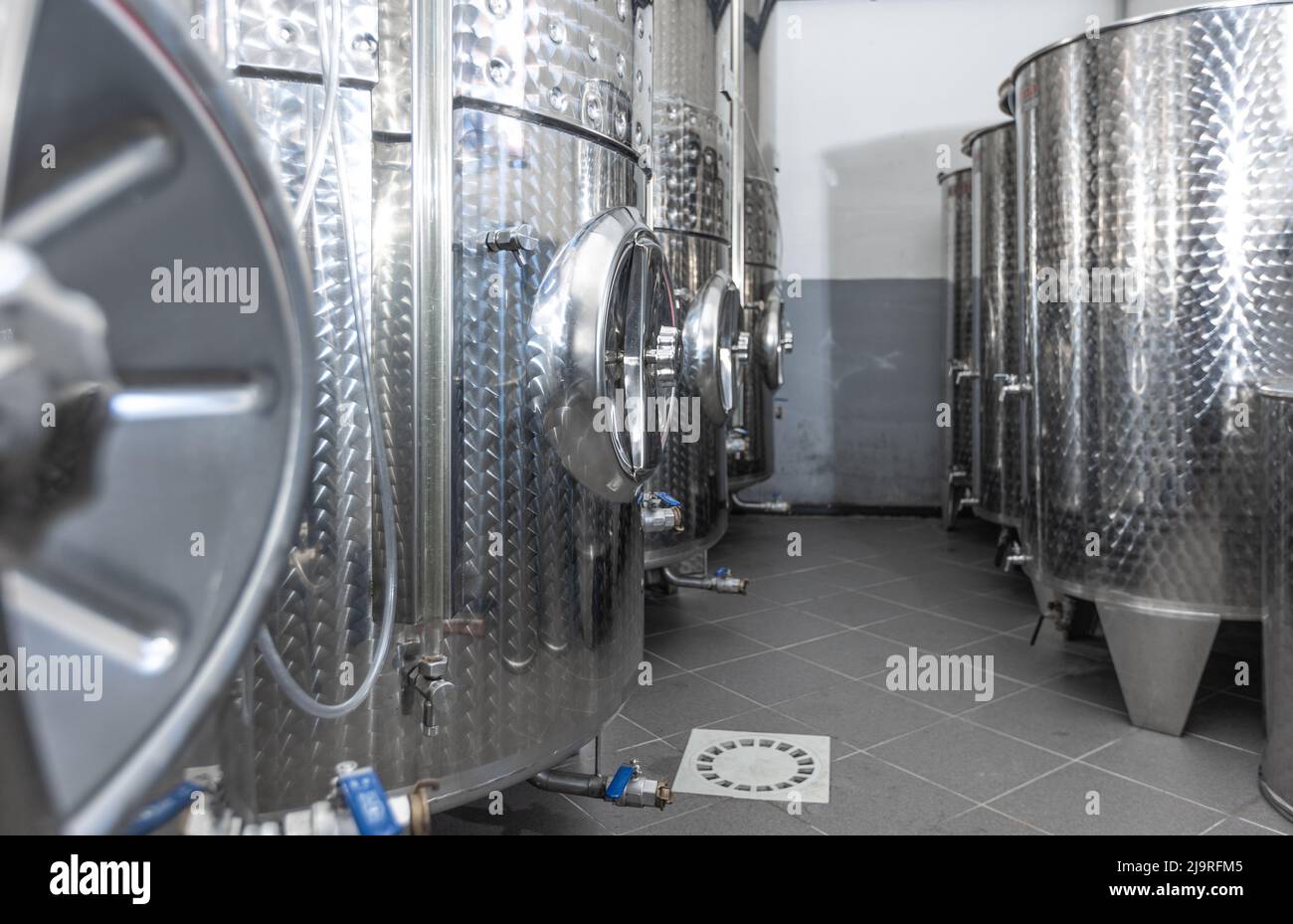 Close up of a wine factory with small steel tanks for storage and ...