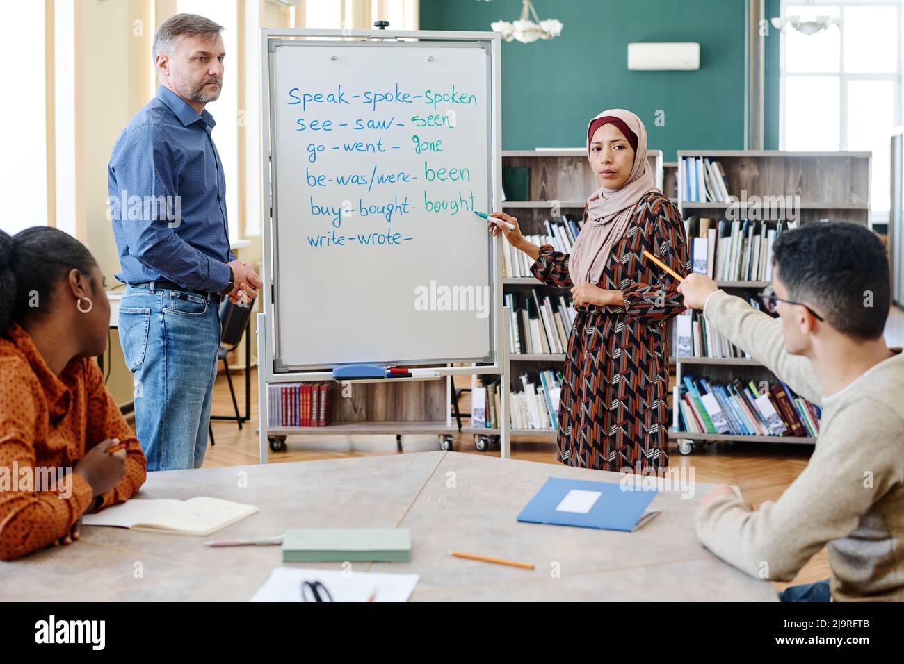 Group of multi-ethnic immigrant students learning English language at ...