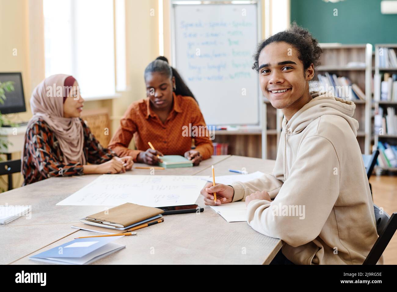 Young Black man sitting at table enjoying learning English language at ...