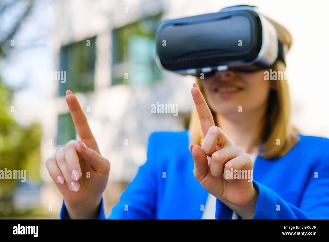 Business woman using VR goggles, moving her head touching the ...