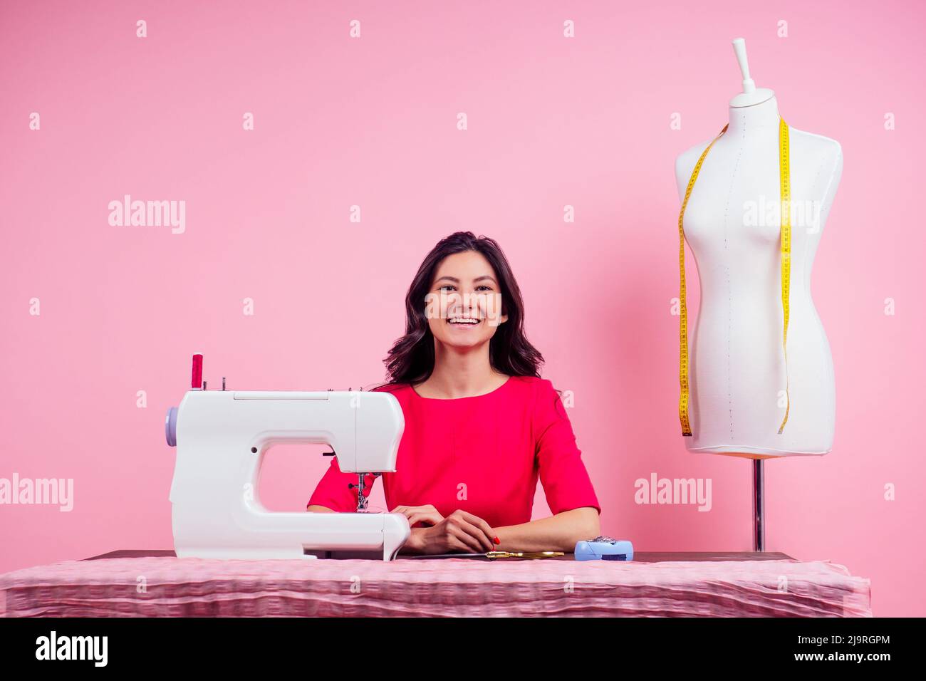 sewing pattern,sewing machine and maniken in studio pink background ...