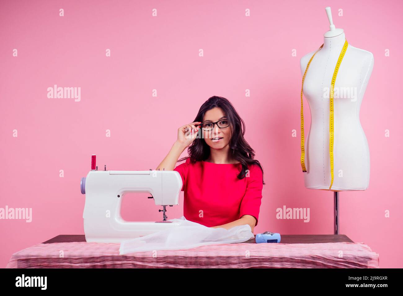 sewing pattern,sewing machine and maniken in studio pink background ...