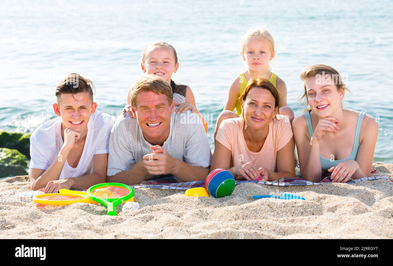 Carefree family of six people lying on beach Stock Photo - Alamy