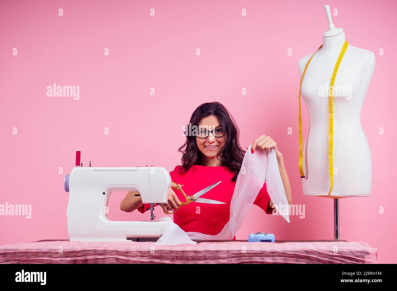 sewing pattern,sewing machine and maniken in studio pink background ...