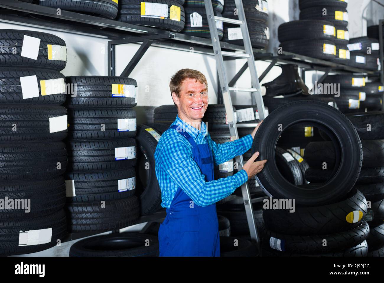 Man fitting new tyre hi-res stock photography and images - Alamy