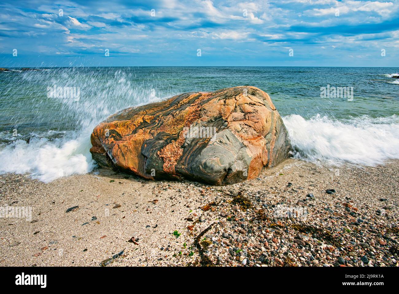 Canada, Quebec, Gulf of St. Lawrence. Ocean spray on colorful shoreline ...