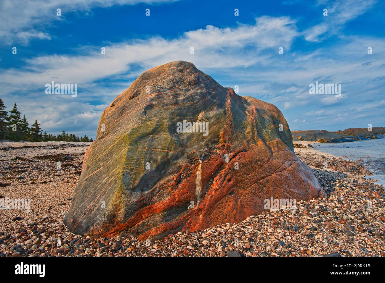 Canada, Quebec, Gulf of St. Lawrence. Colorful boulder on shoreline ...